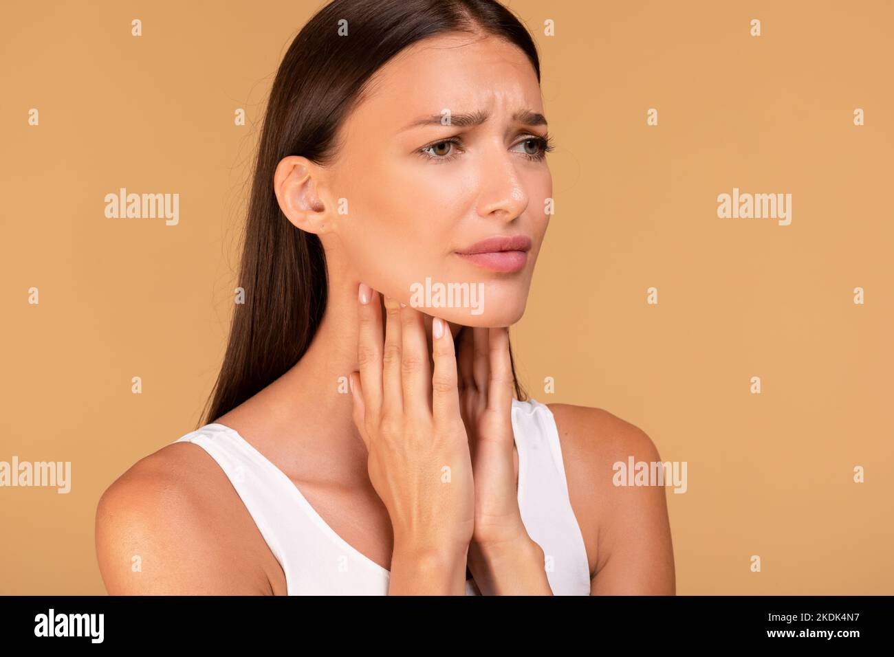 Unhappy caucasian lady suffering from pain in throat, touching her neck ...