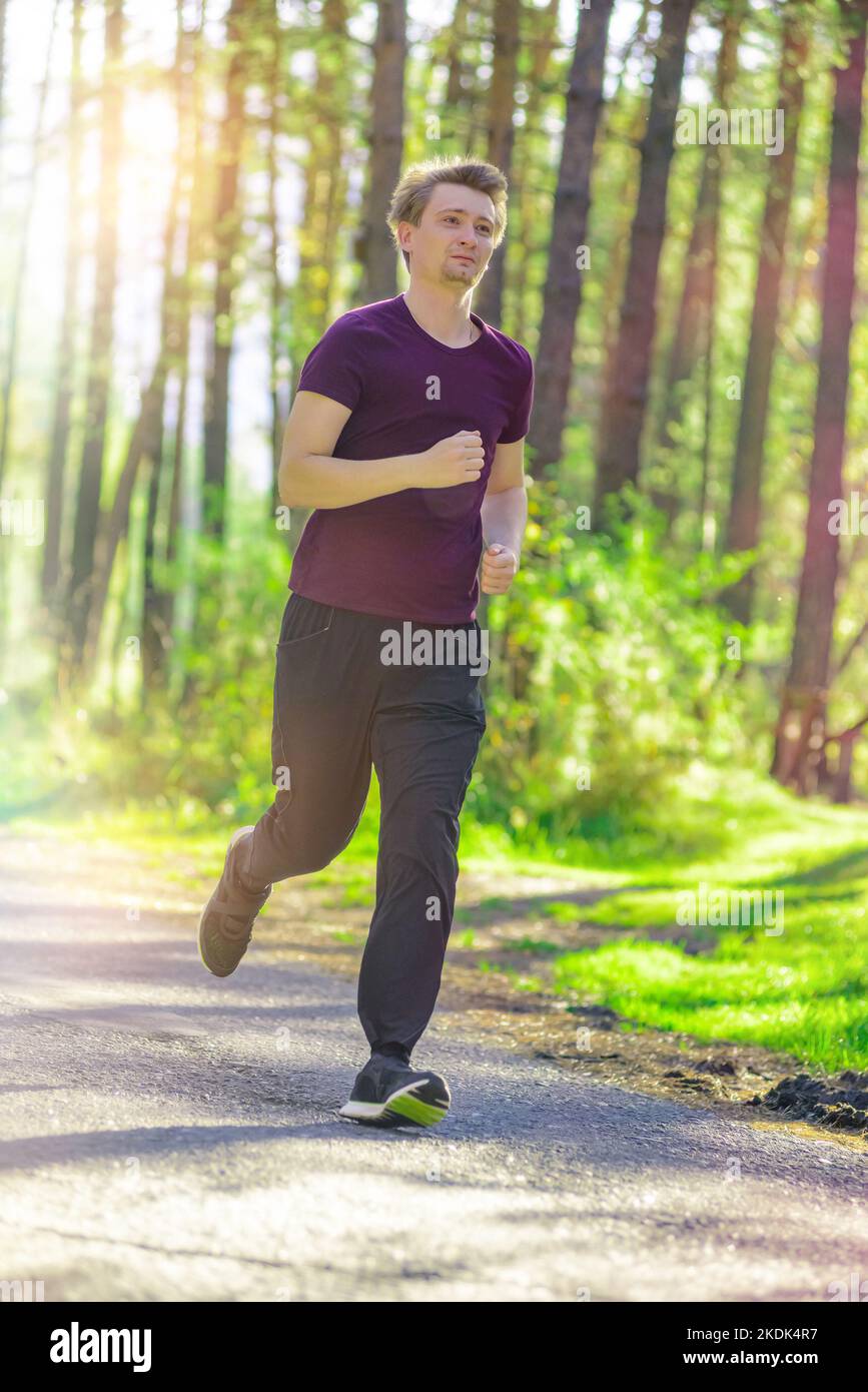 Running man jogging in city park at beautiful summer day. Sport fitness ...