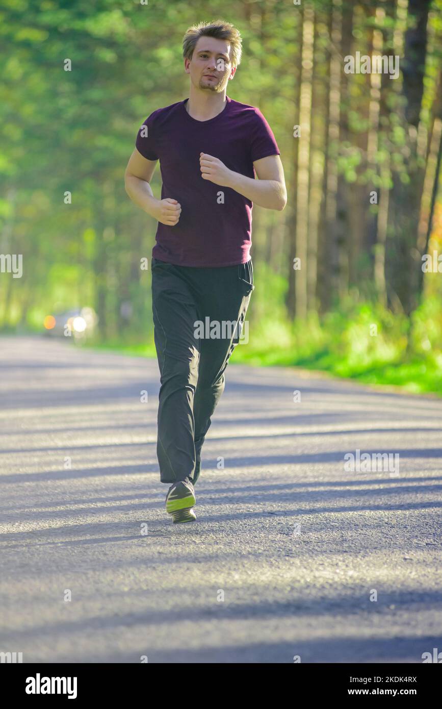 Running man jogging in city park at beautiful summer day. Sport fitness ...