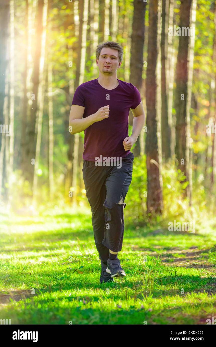 Running man jogging in city park at beautiful summer day. Sport fitness ...