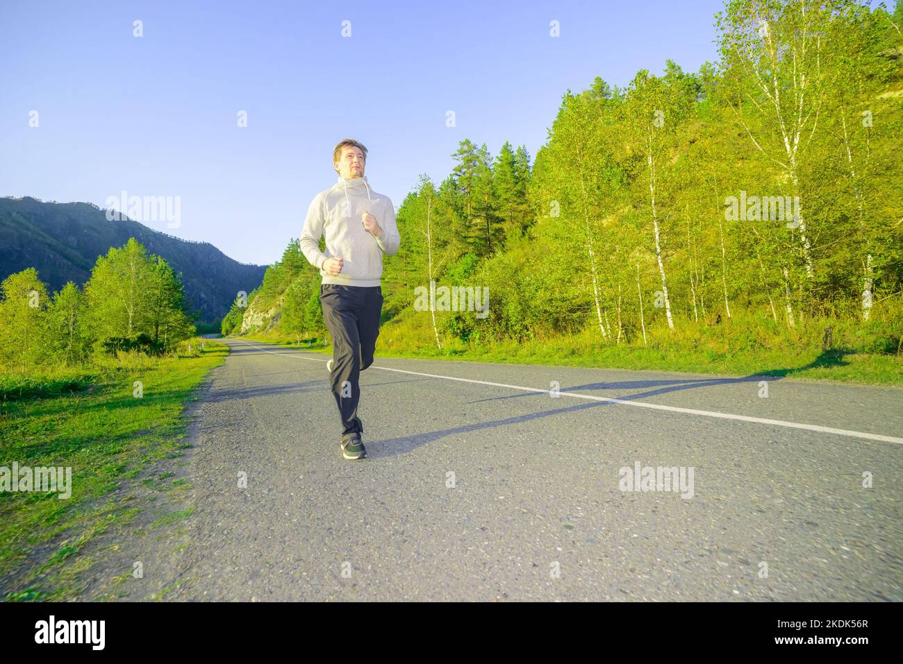 Running man jogging in city park at beautiful summer day. Sport fitness ...