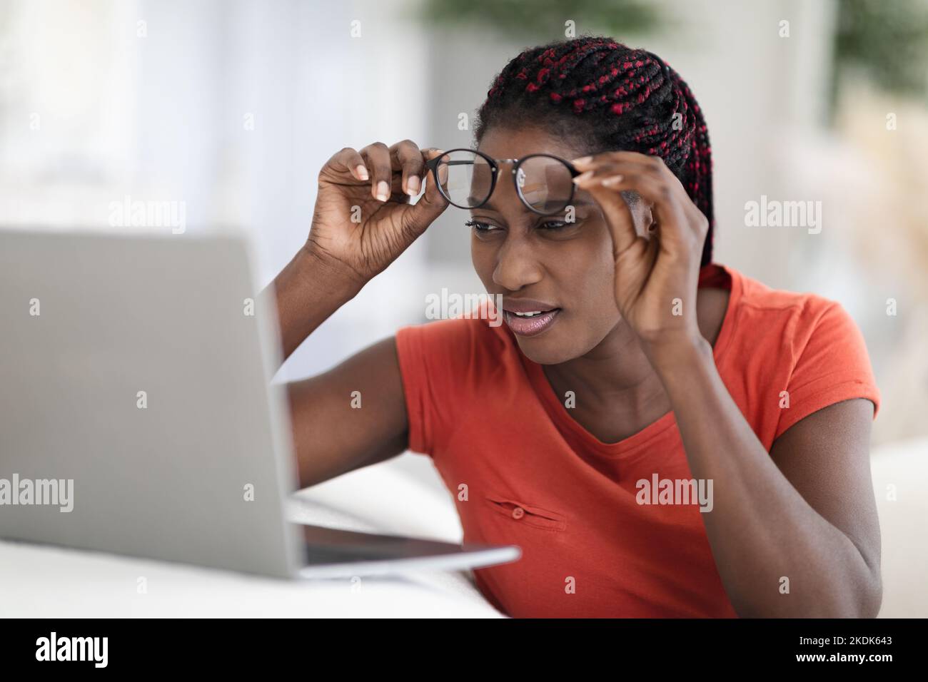 Confused Black Woman Taking Off Eyeglasses And Looking At Laptop Screen ...