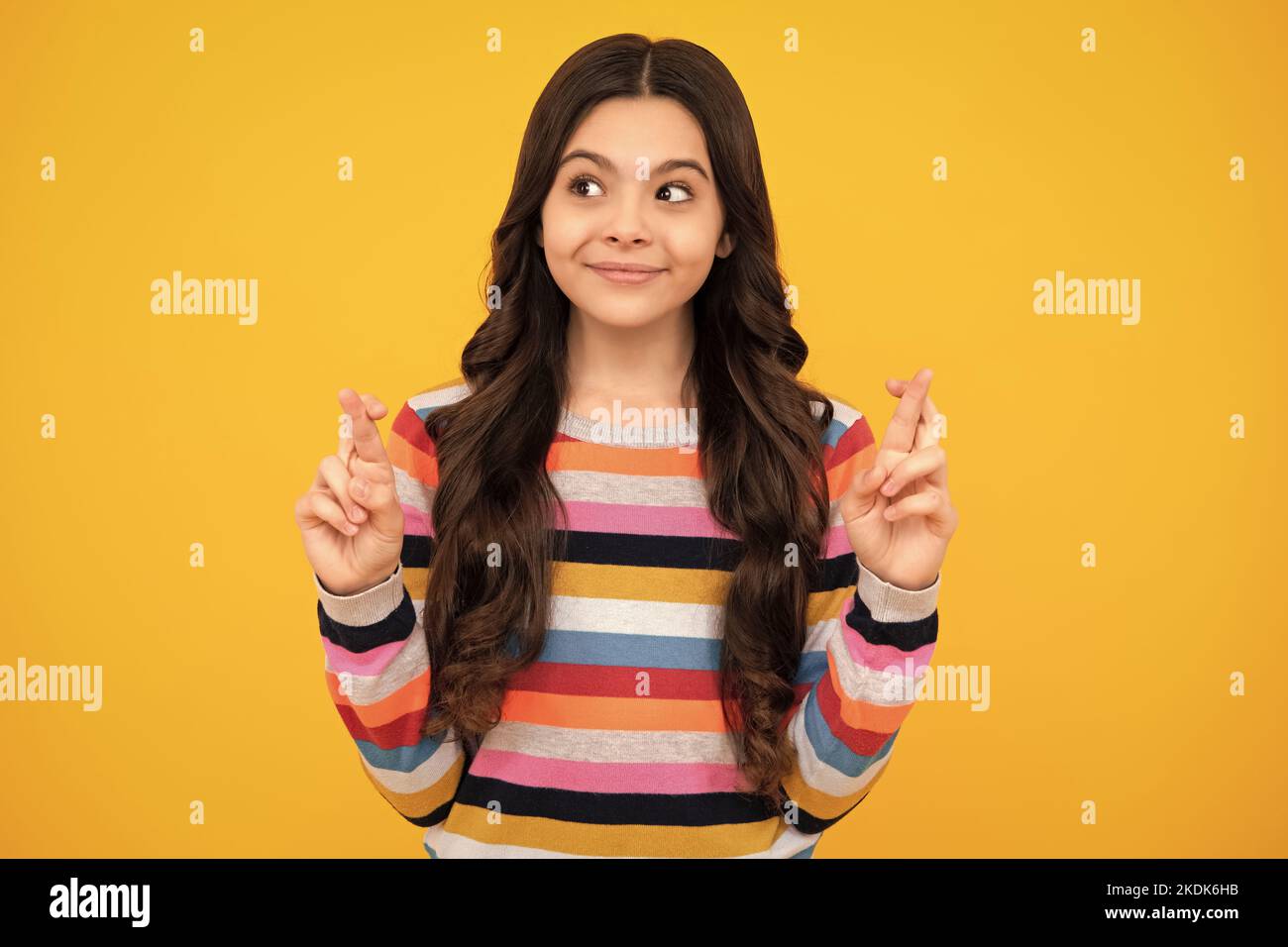 Teenager child holding fingers crossed for good luck. Girl prays and ...