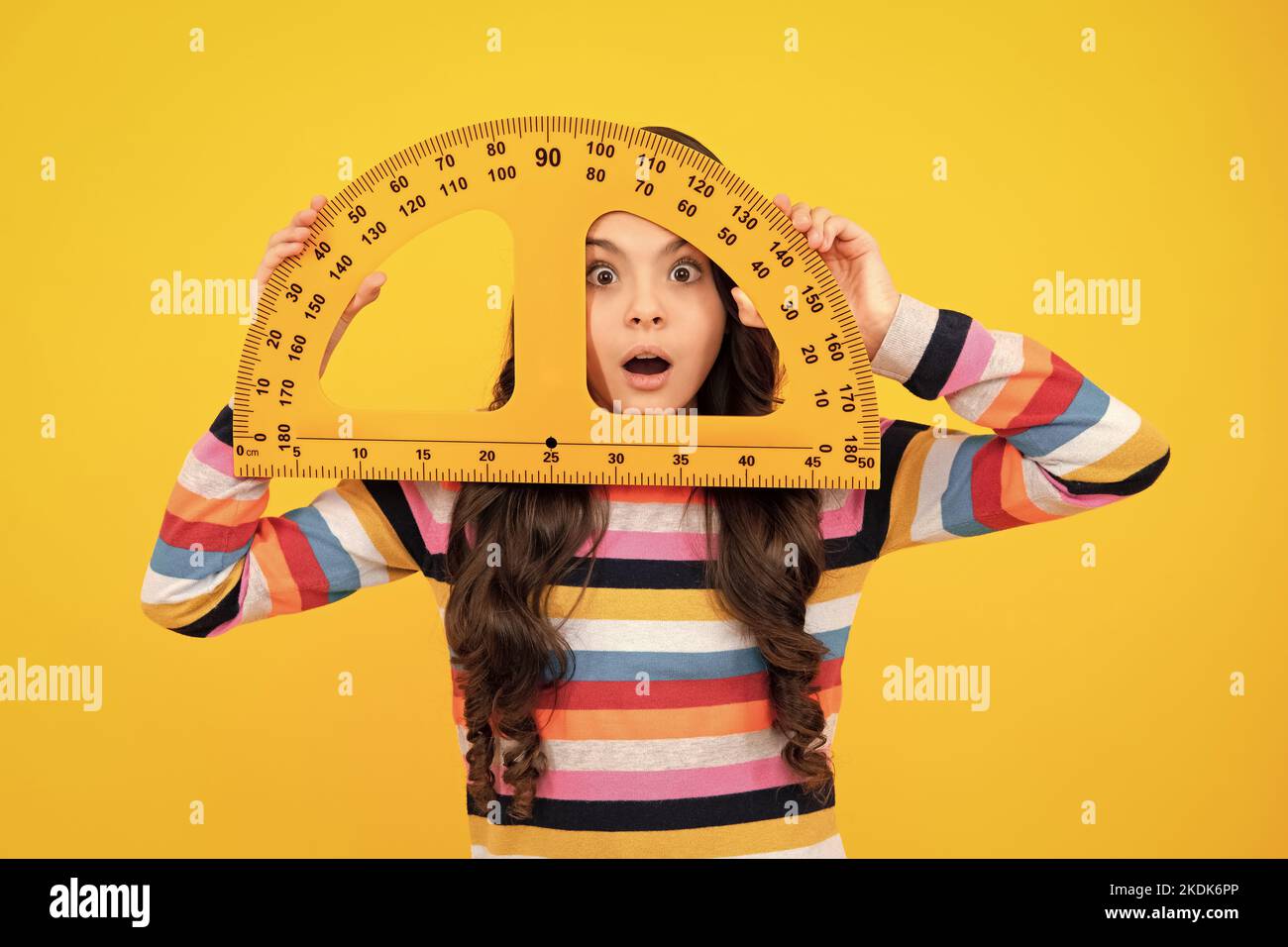 Amazed teenager. Teenager child school girl holding measure for ...