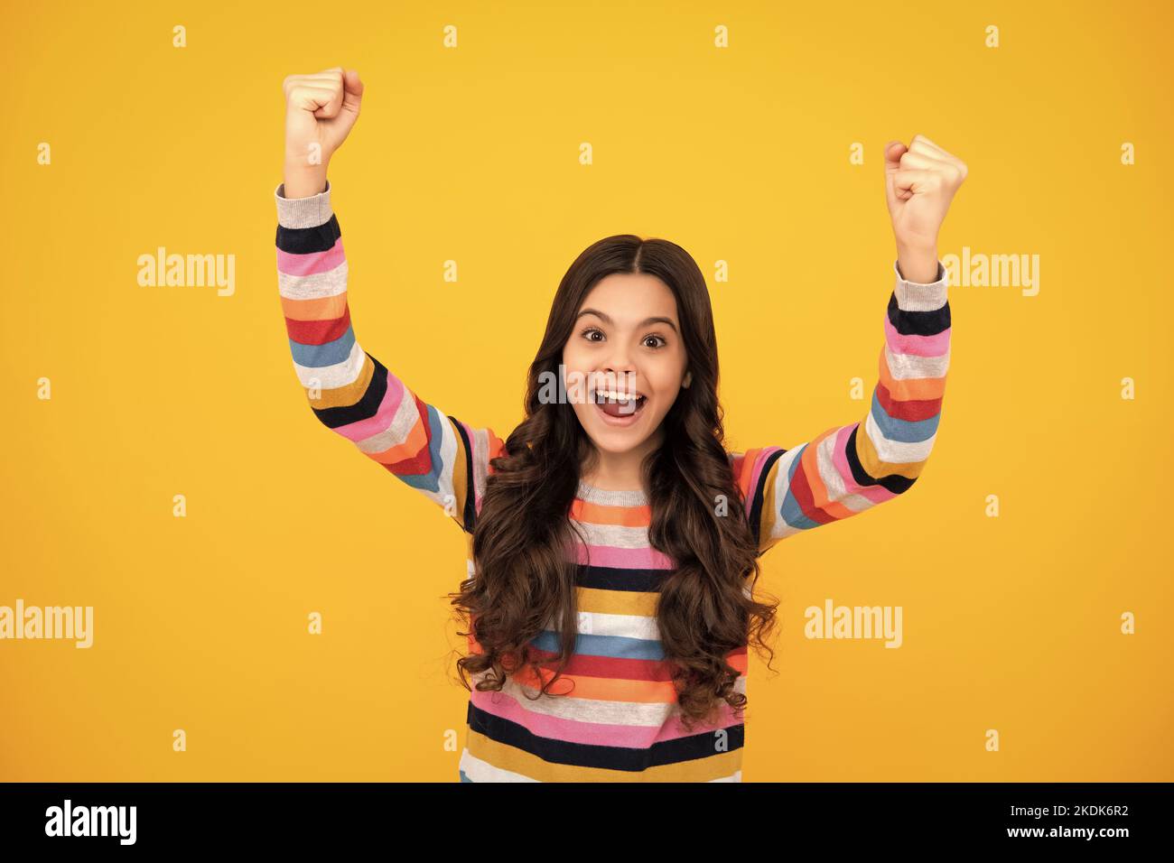 Amazed teenager. Studio portrait of teenager child doing winner gesture ...