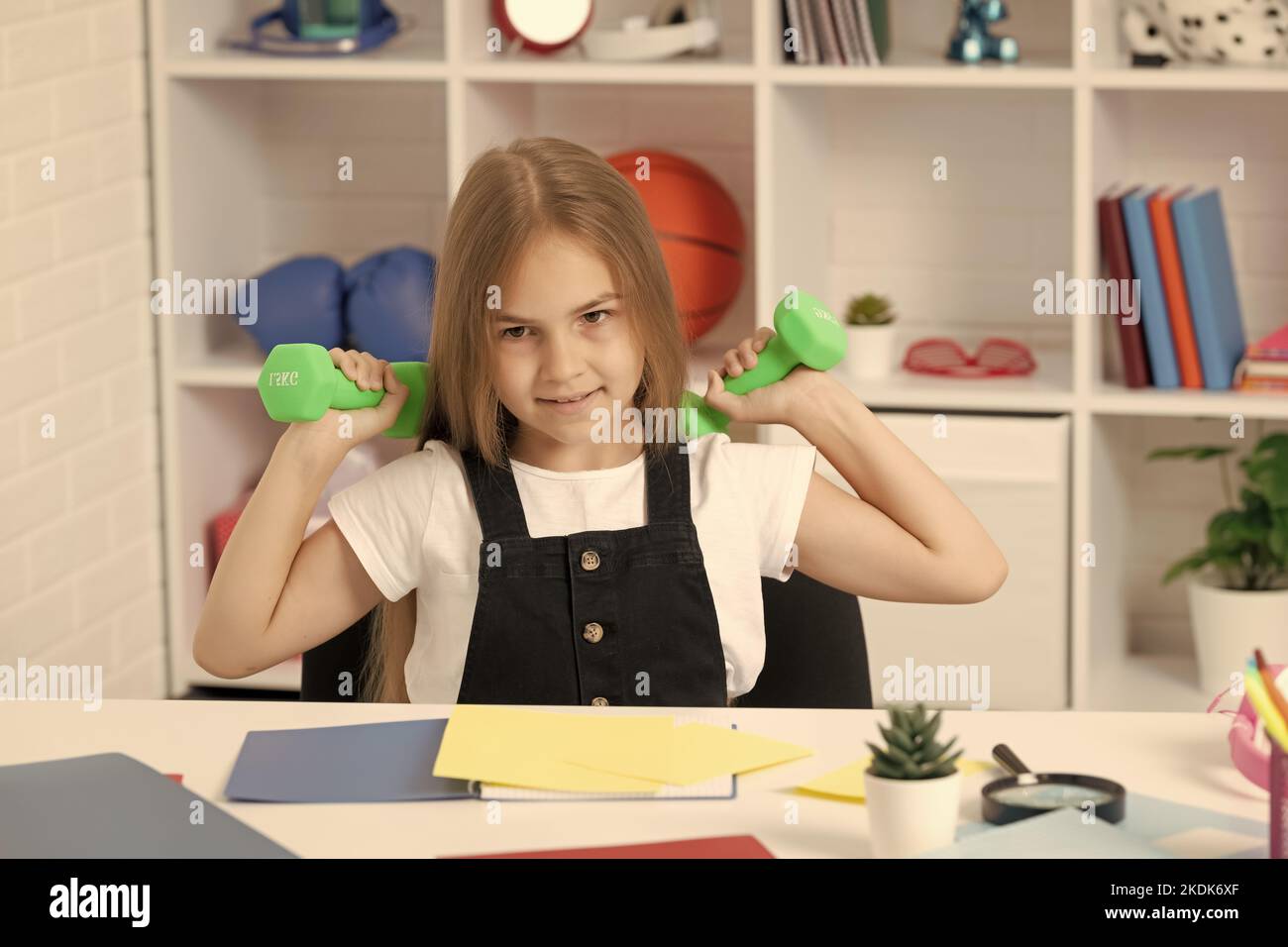 kid hold sport barbells in school classroom Stock Photo - Alamy