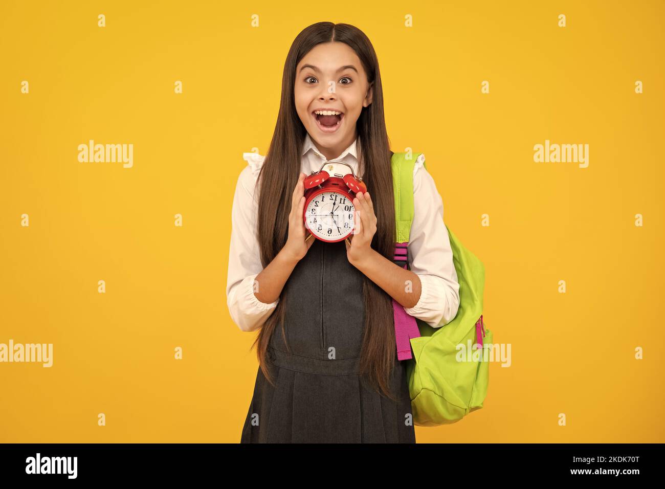 Back to school. Teenager school girl with backpack hold clock alarm ...