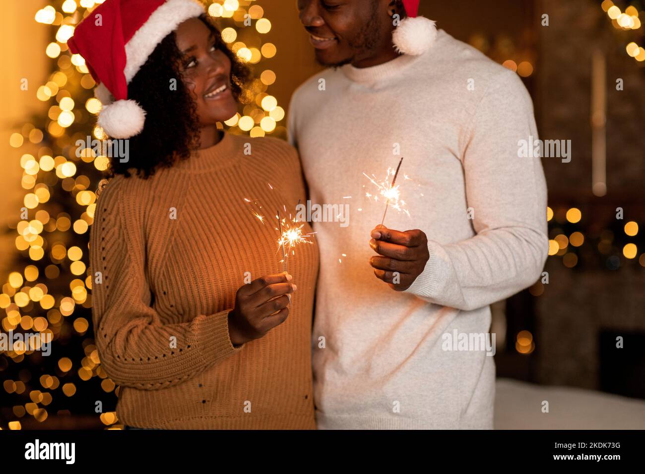 Smiling millennial african american wife hug husband in Santa Claus hat ...