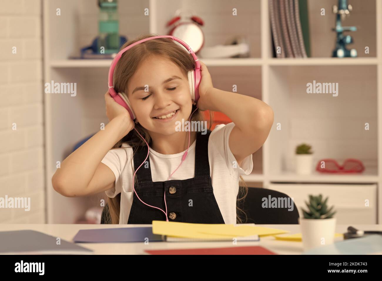 smiling child listen to music in headphones at school classroom Stock ...