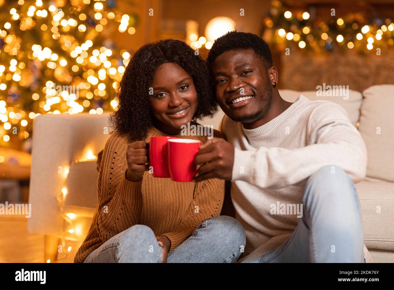 Cheerful Millennial Black Man And Lady Cheers With Cups Of Favorite Hot