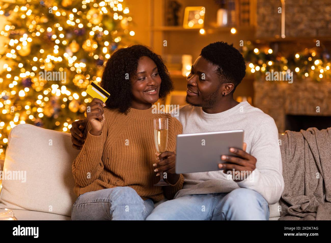 Happy millennial black family enjoy holiday with glass of champagne ...