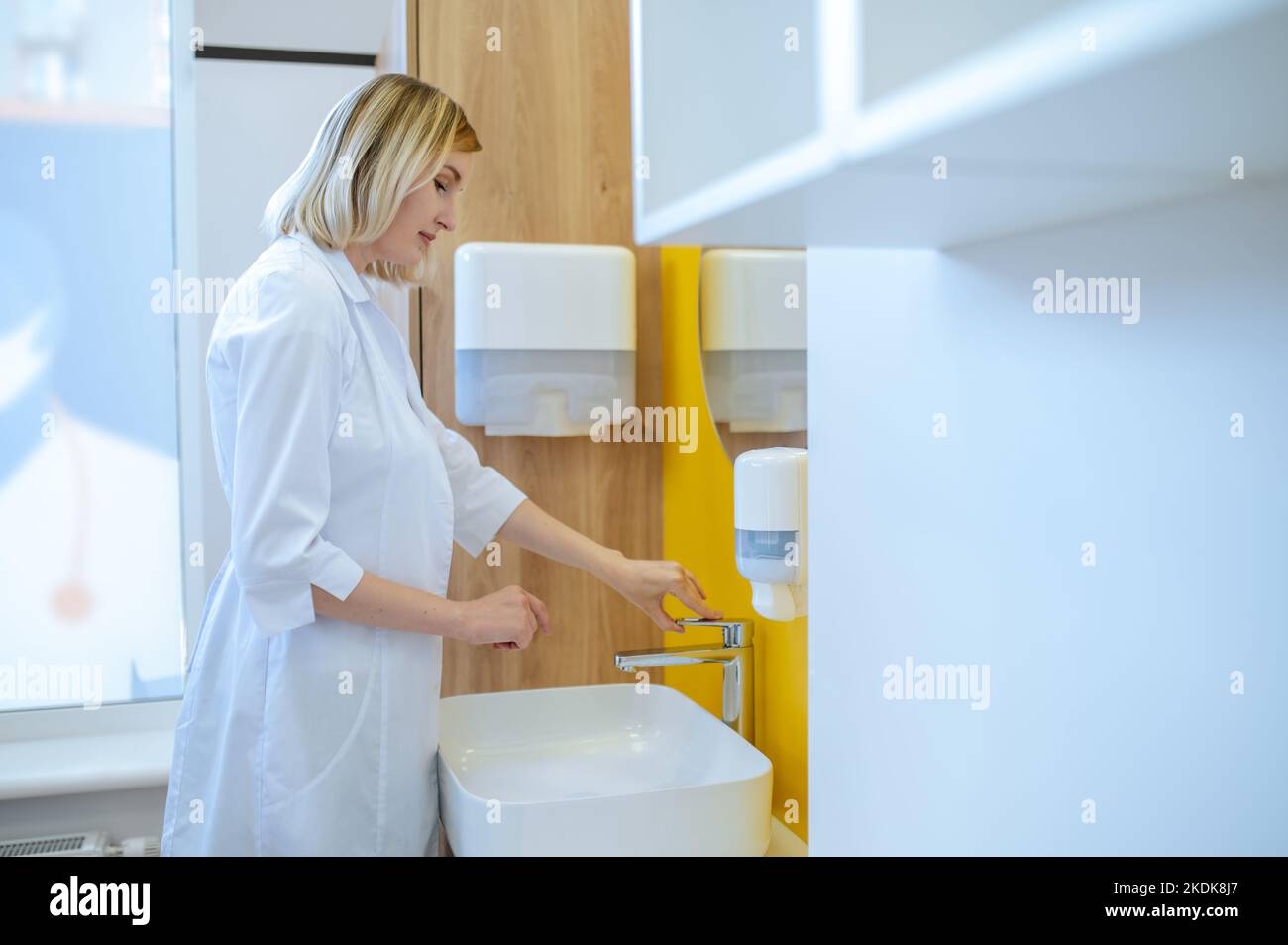 Female doctor washing hands in the bathroom Stock Photo - Alamy