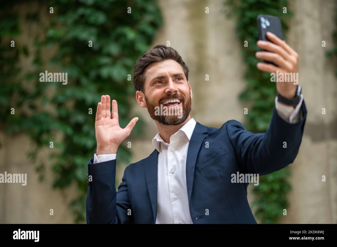 Smiling businessman having a video call and looking excited Stock Photo ...
