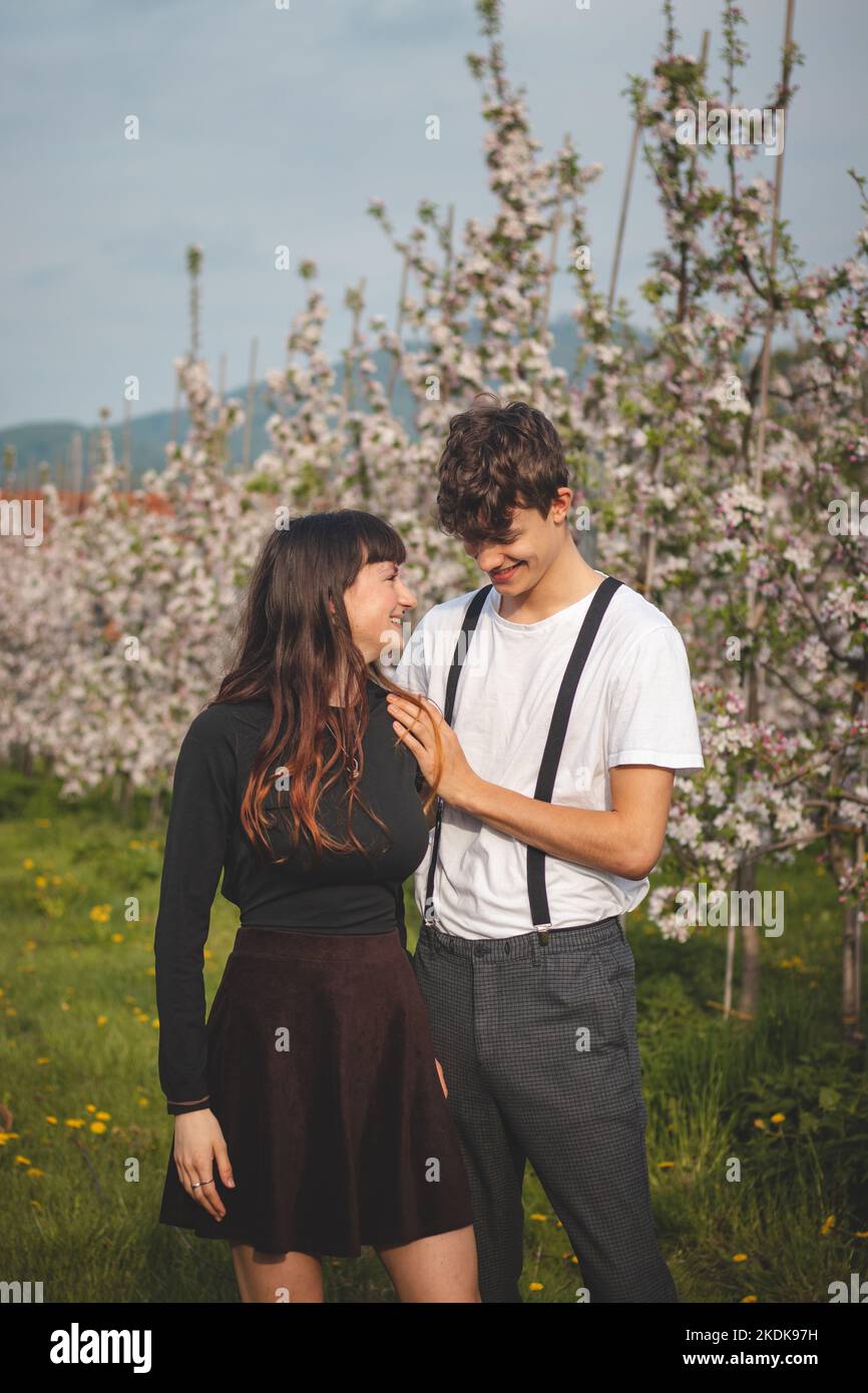 Beautiful strong love between two young people walking under apple ...