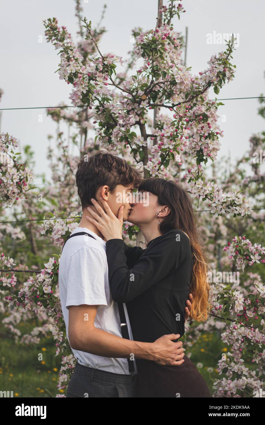 Young strong love between two wonderful people walking under apple ...