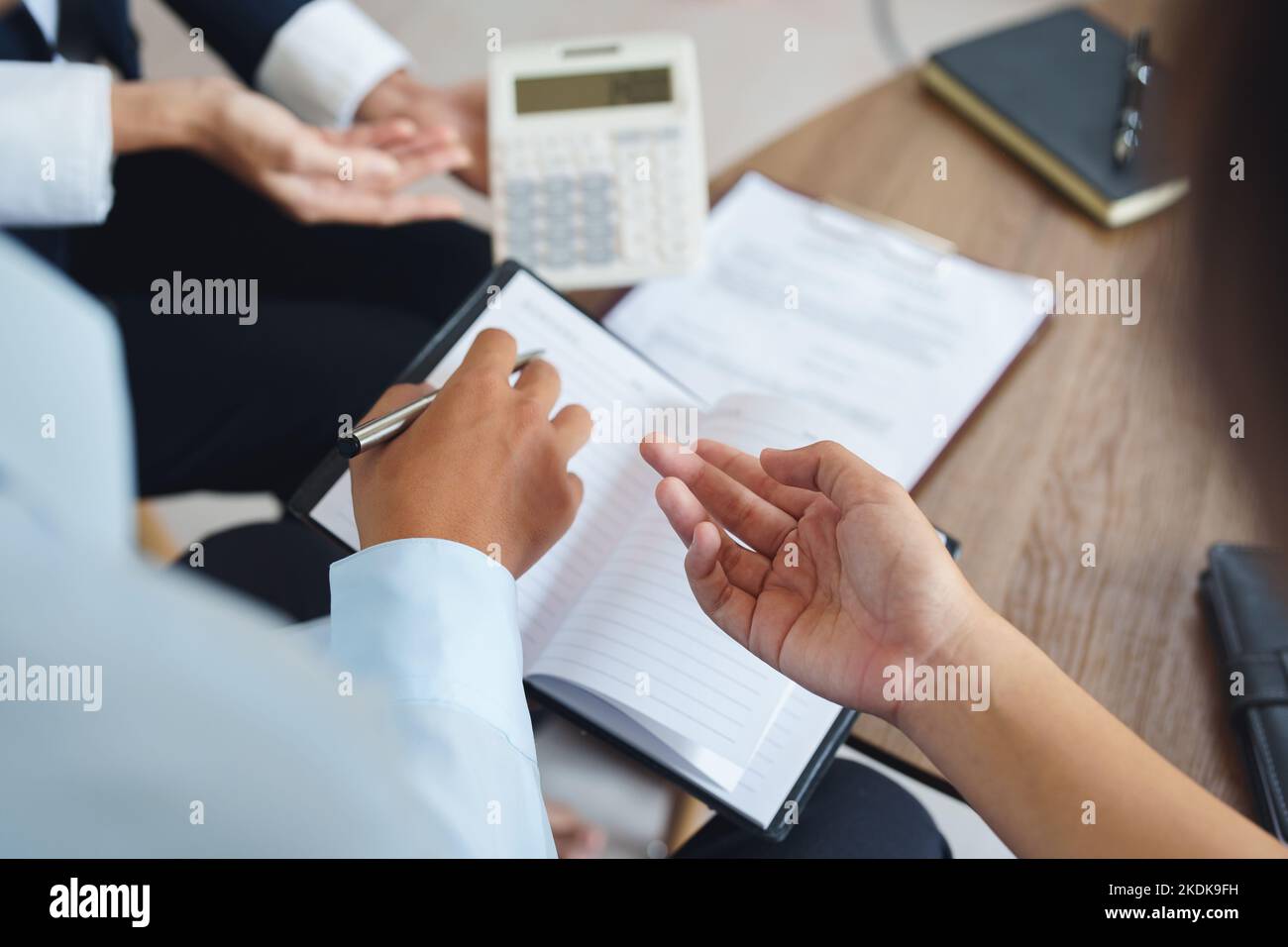 bank employee uses a calculator to calculate loan rates for customers ...