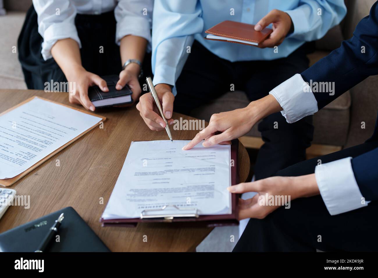 Couples sign important documents with insurance agents Stock Photo - Alamy