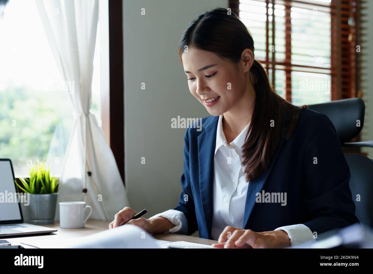 Portrait of an Asian accountant checking accounts for customers Stock ...