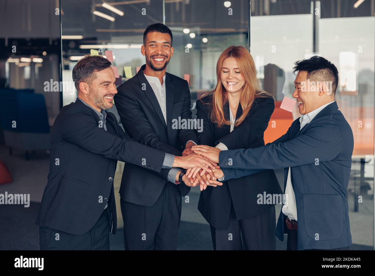 Happy group of multi ethnic coworkers stacked hands together as concept ...