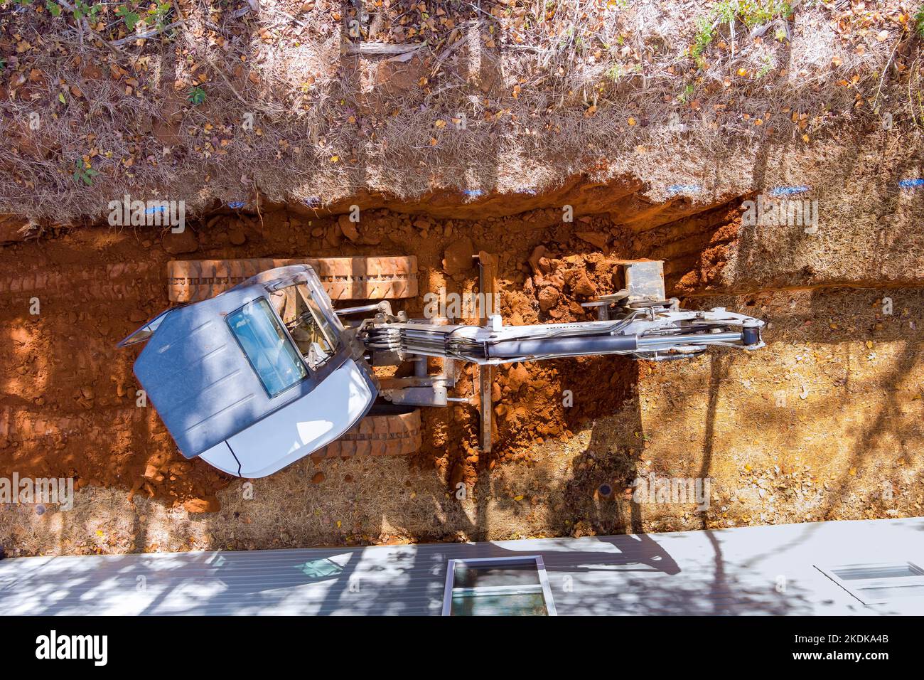 An earthmoving worker digging ground at construction site with crawler ...