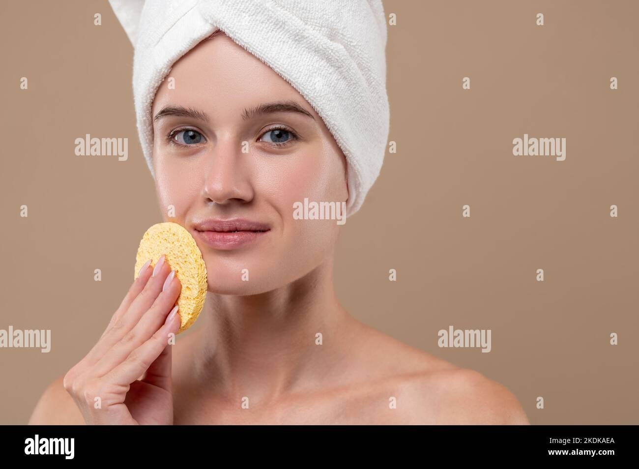 Pretty young girl cleaning her face with a sponge Stock Photo - Alamy