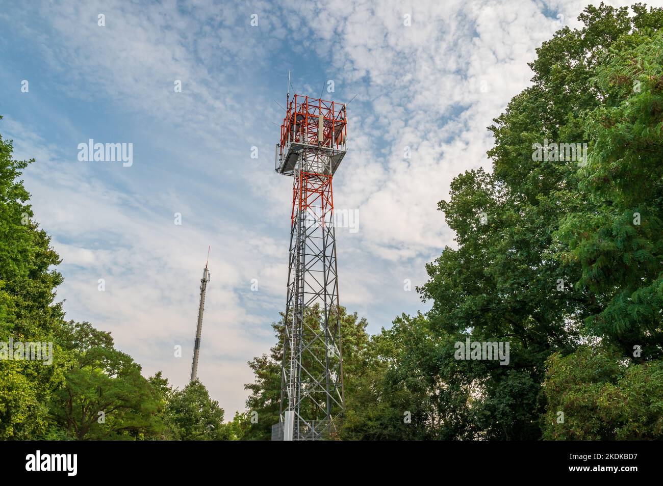 5G telecommunications tower and single cellular provider mast framed by ...
