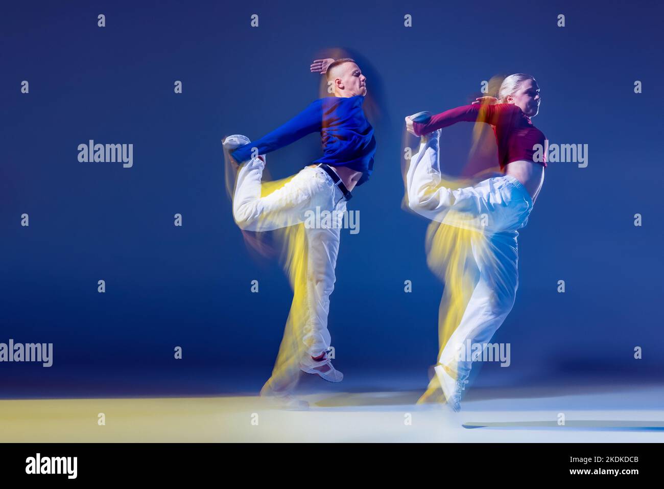 Portrait of young man and woman synchronically dancing isolated over ...
