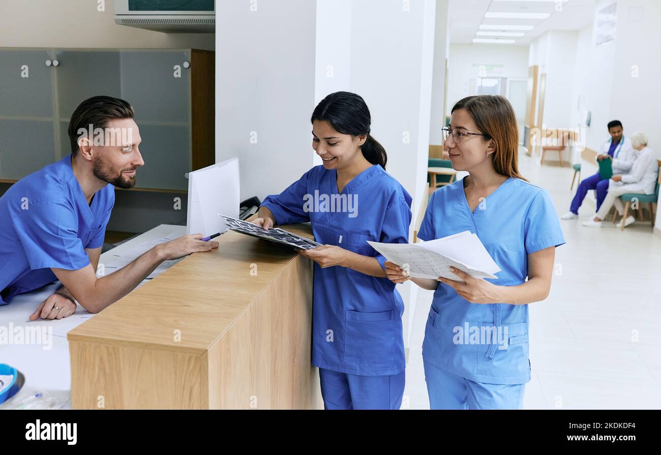 medical employees. medical assistant on duty talking with female nurses ...