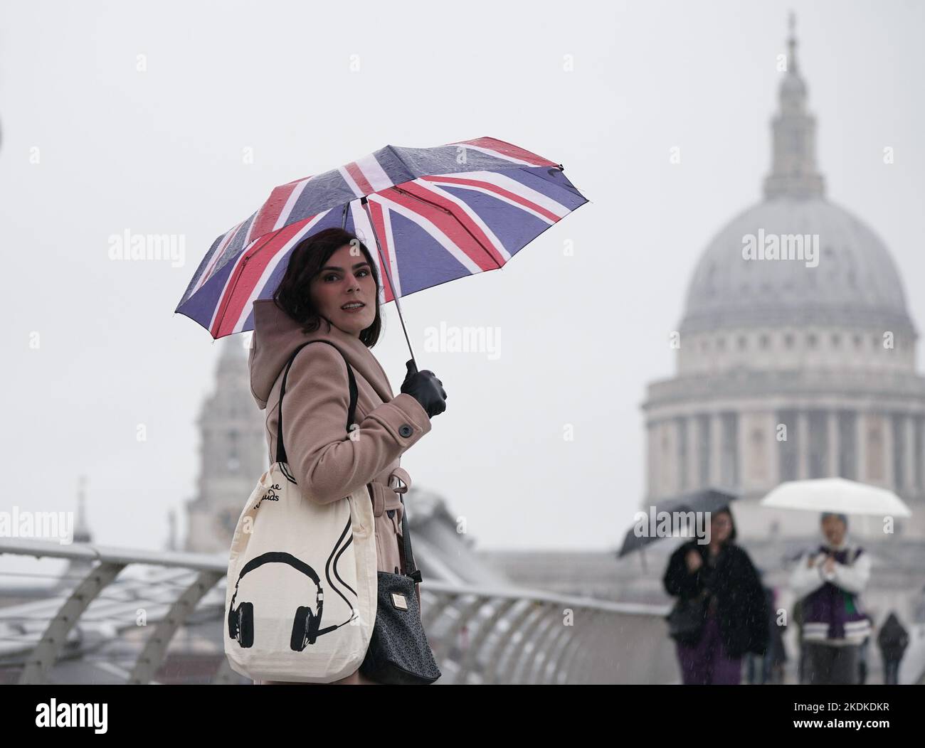A woman holding a Union Jack umbrella during a rain shower, on the ...