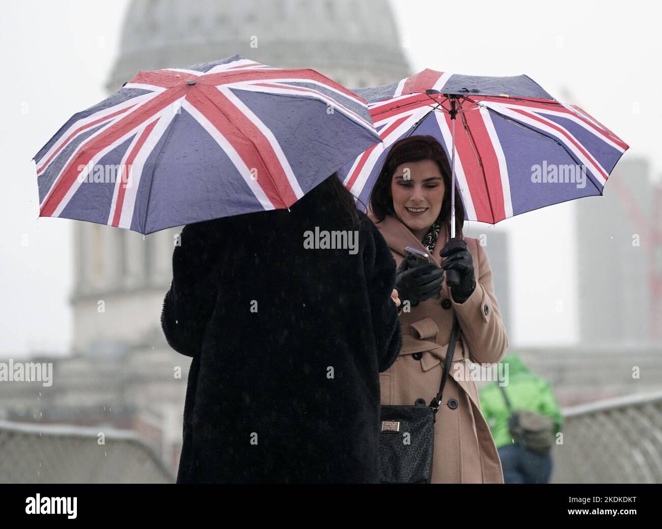 Two women holding Union Jack umbrellas during a rain shower, on the ...