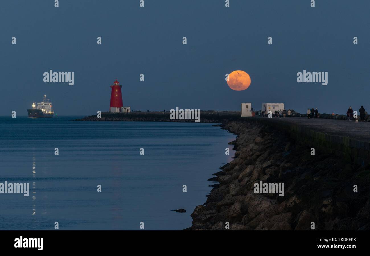 Full moonrise over the Half Moon swimming club at the Great South Wall ...