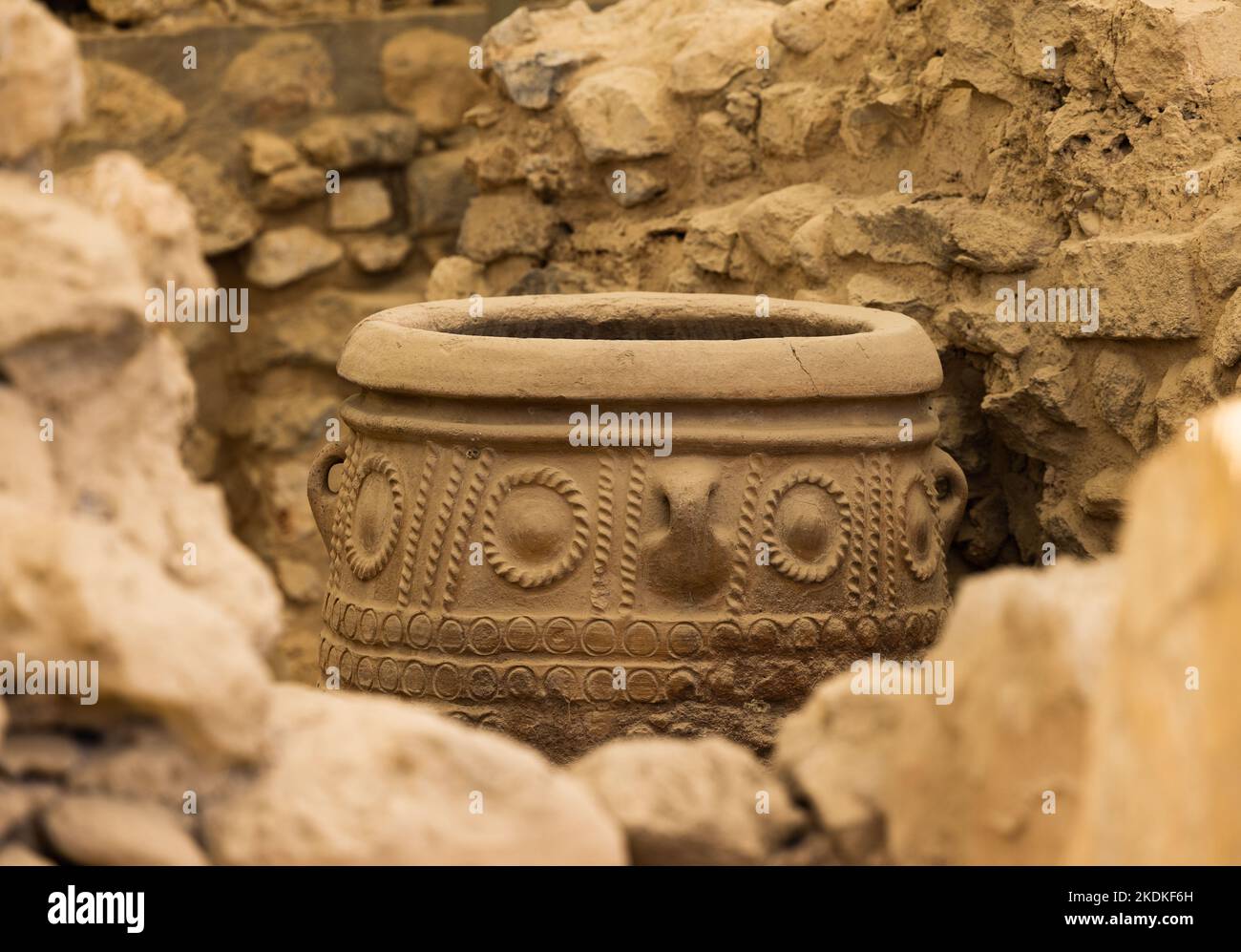 Detail of an ancient clay vase surrounded by stones in Knossos Palace ...