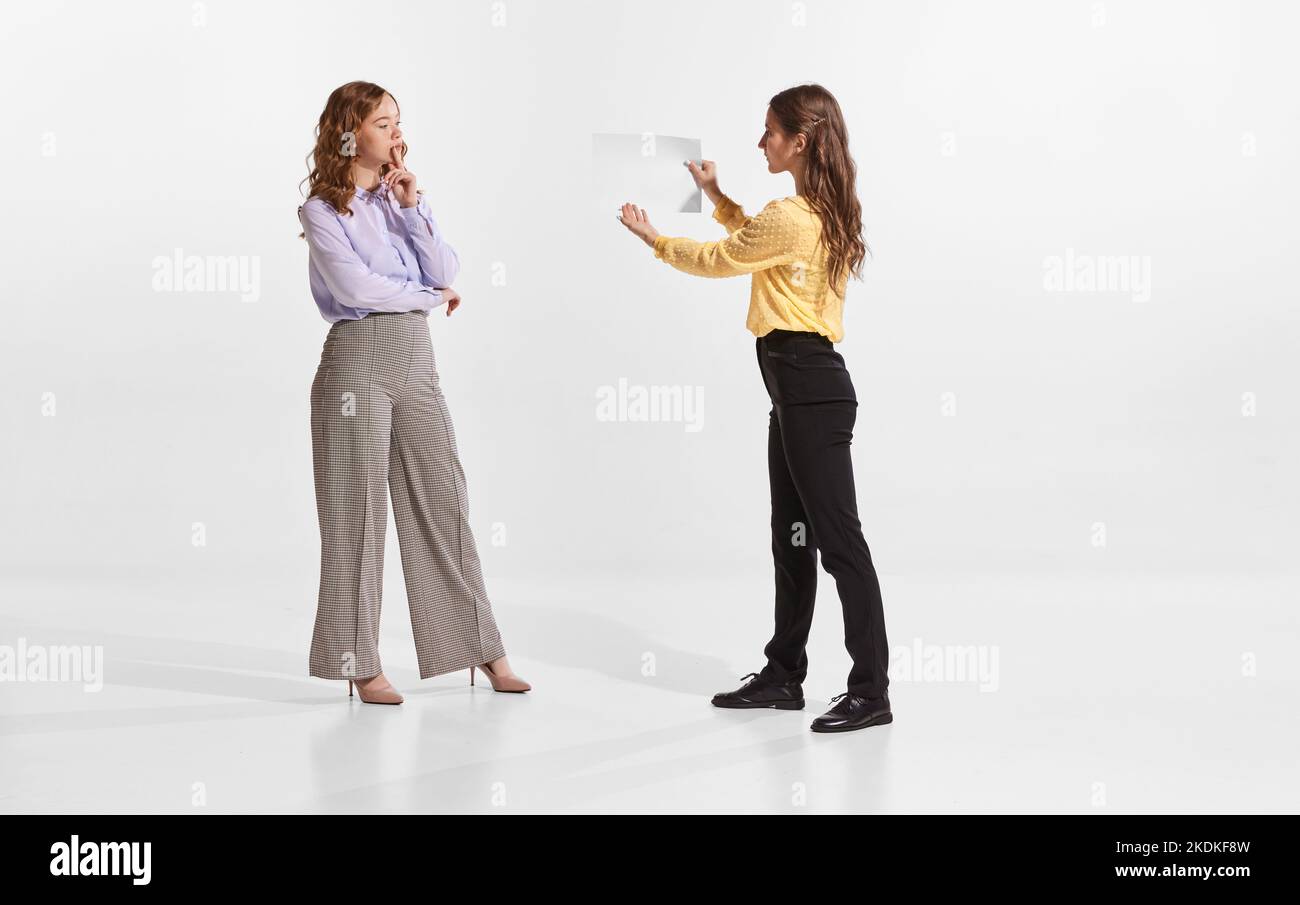 Portrait of two women, employees working together, discussing business analytics isolated over ...
