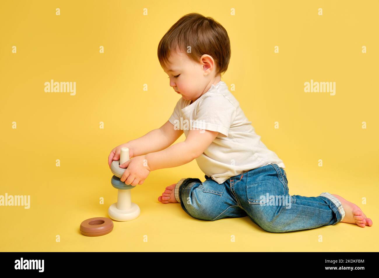 Toddler baby is playing logic educational games with a pyramid on a ...