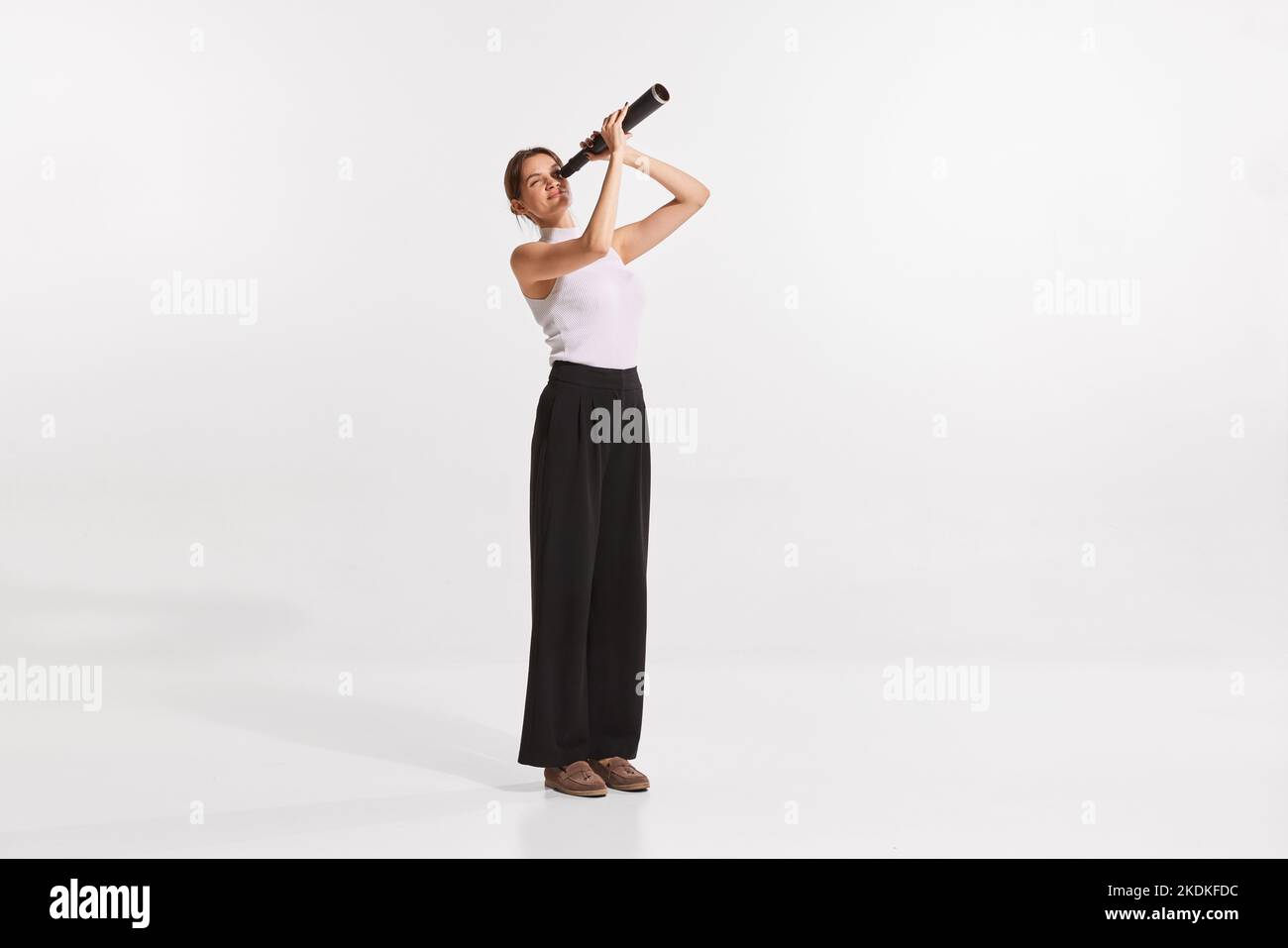 Portrait of young woman looking in telescope isolated over white ...