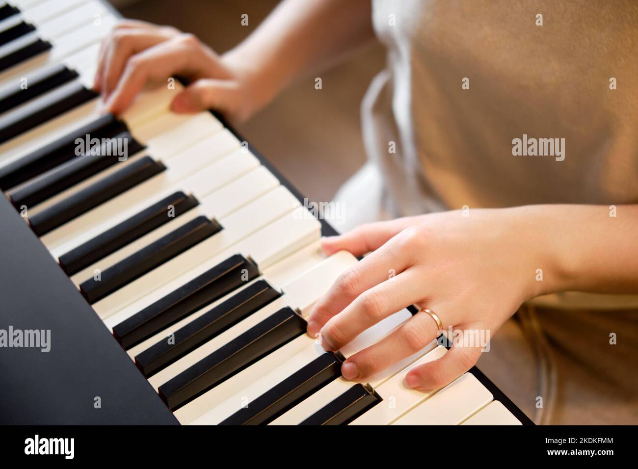 An adult woman plays an electric piano, hands close-up. Female hands on ...