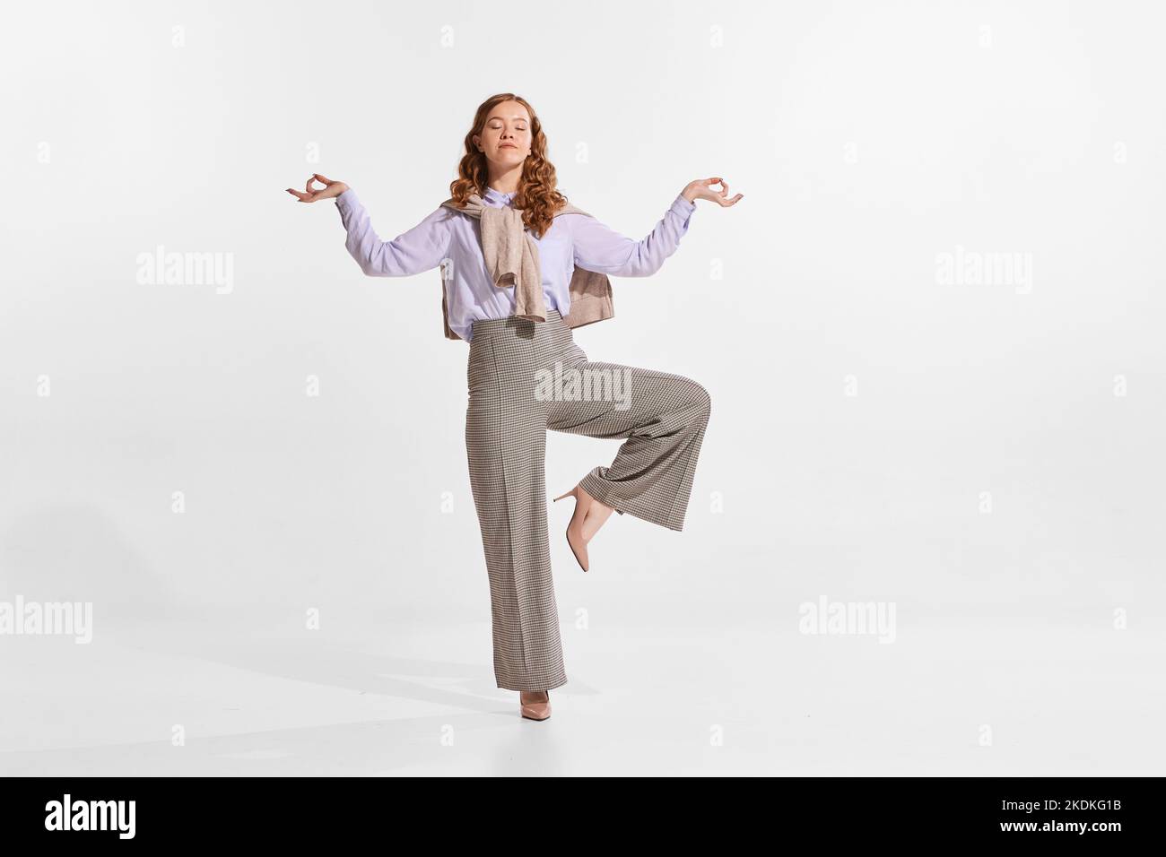 Portrait of young woman, employee meditating isolated over white studio ...