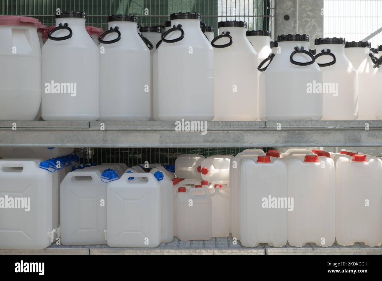 New Empty white plastic cans with red lids on a rack. Different ...