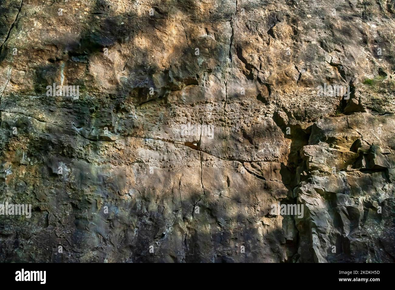 Tall limestone cliffs, partly quarried, with cave entrances and man ...