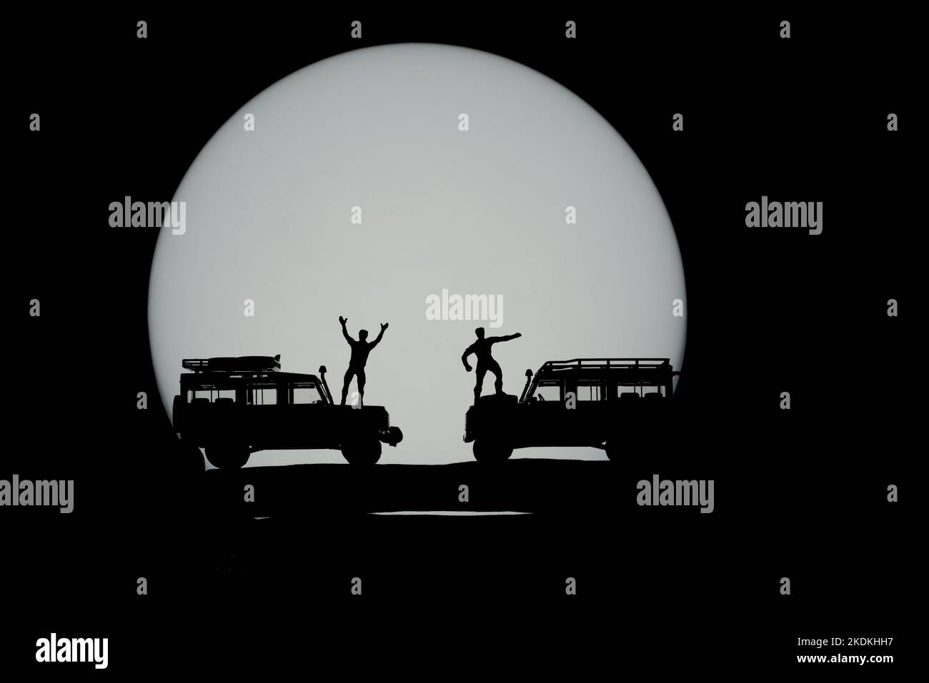 Miniature toys of two men celebrate triumphantly at the mountain ...