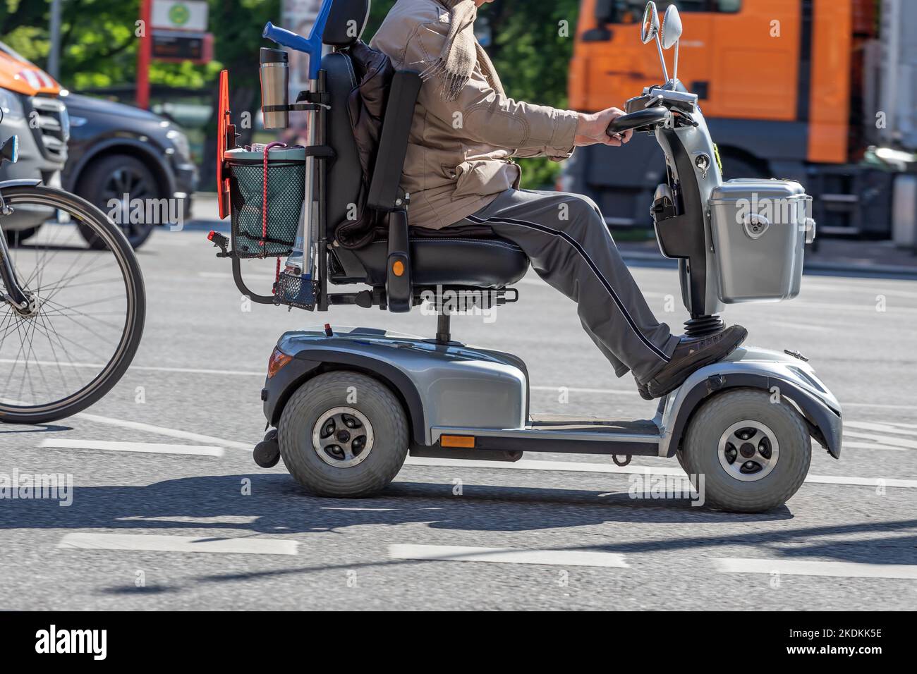 elderly man on electric wheelchair rides on the street Stock Photo - Alamy