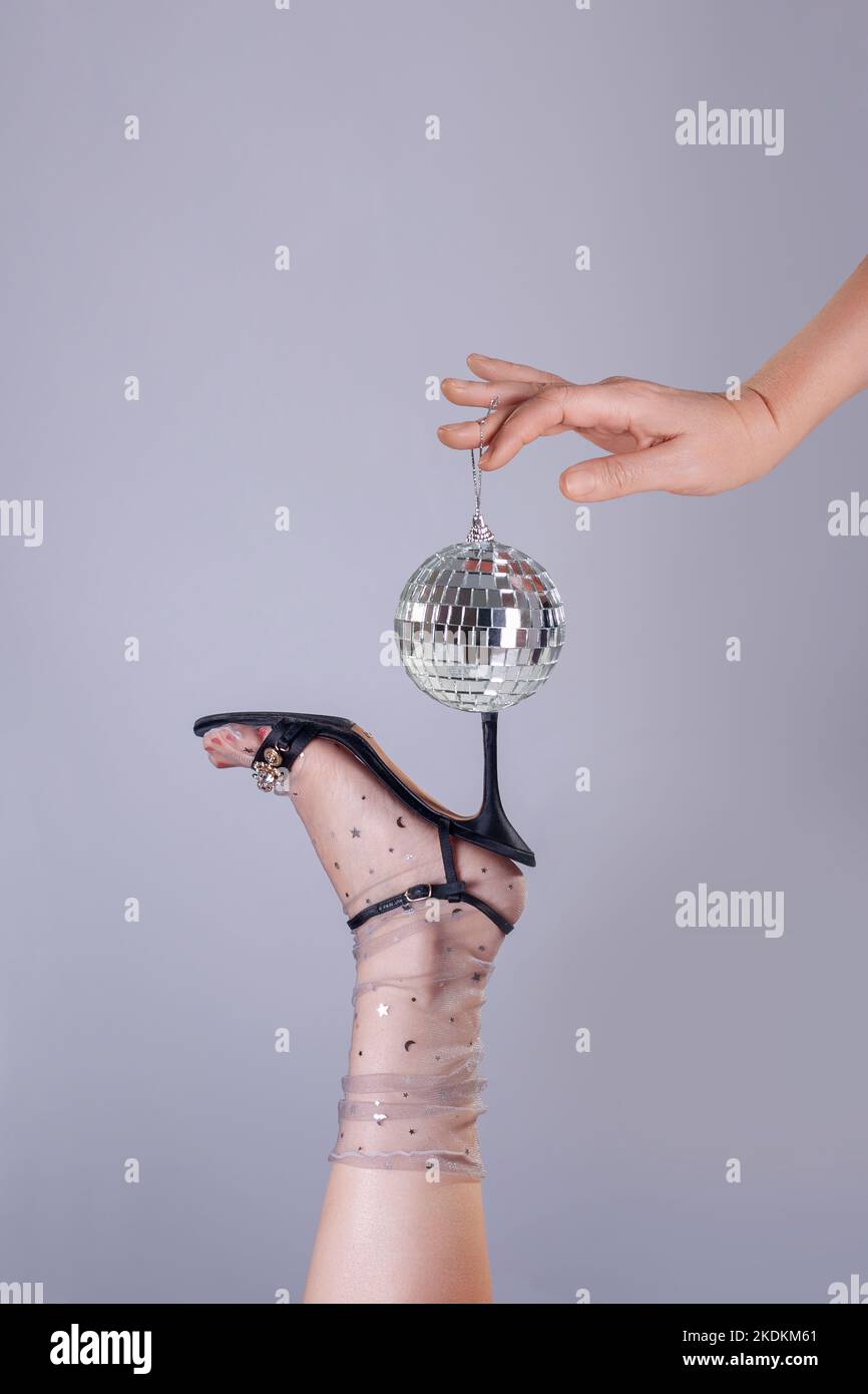 An inverted female leg in black evening sandals with heels and ...