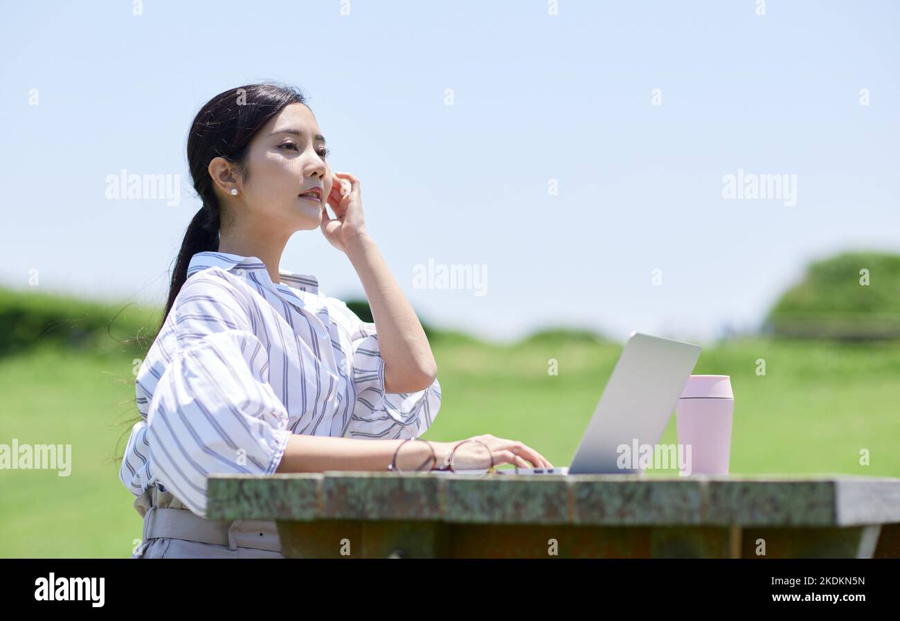 Young Japanese woman working outside Stock Photo - Alamy