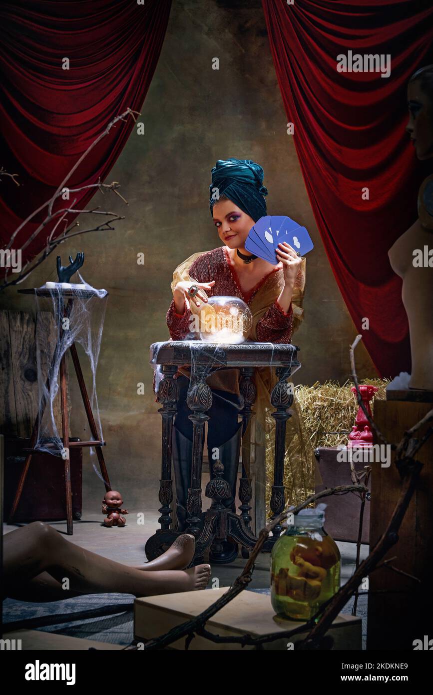 Portrait of magnificent fortune teller woman reading future on magical ...