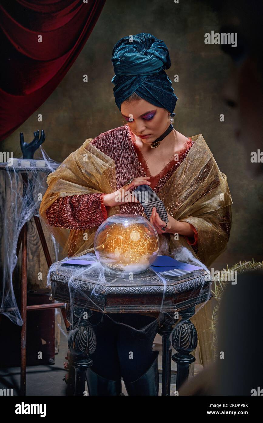 Portrait of magnificent fortune teller woman reading future on magical ...