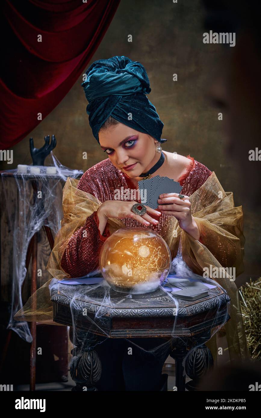 Portrait of magnificent fortune teller woman reading future on magical ...