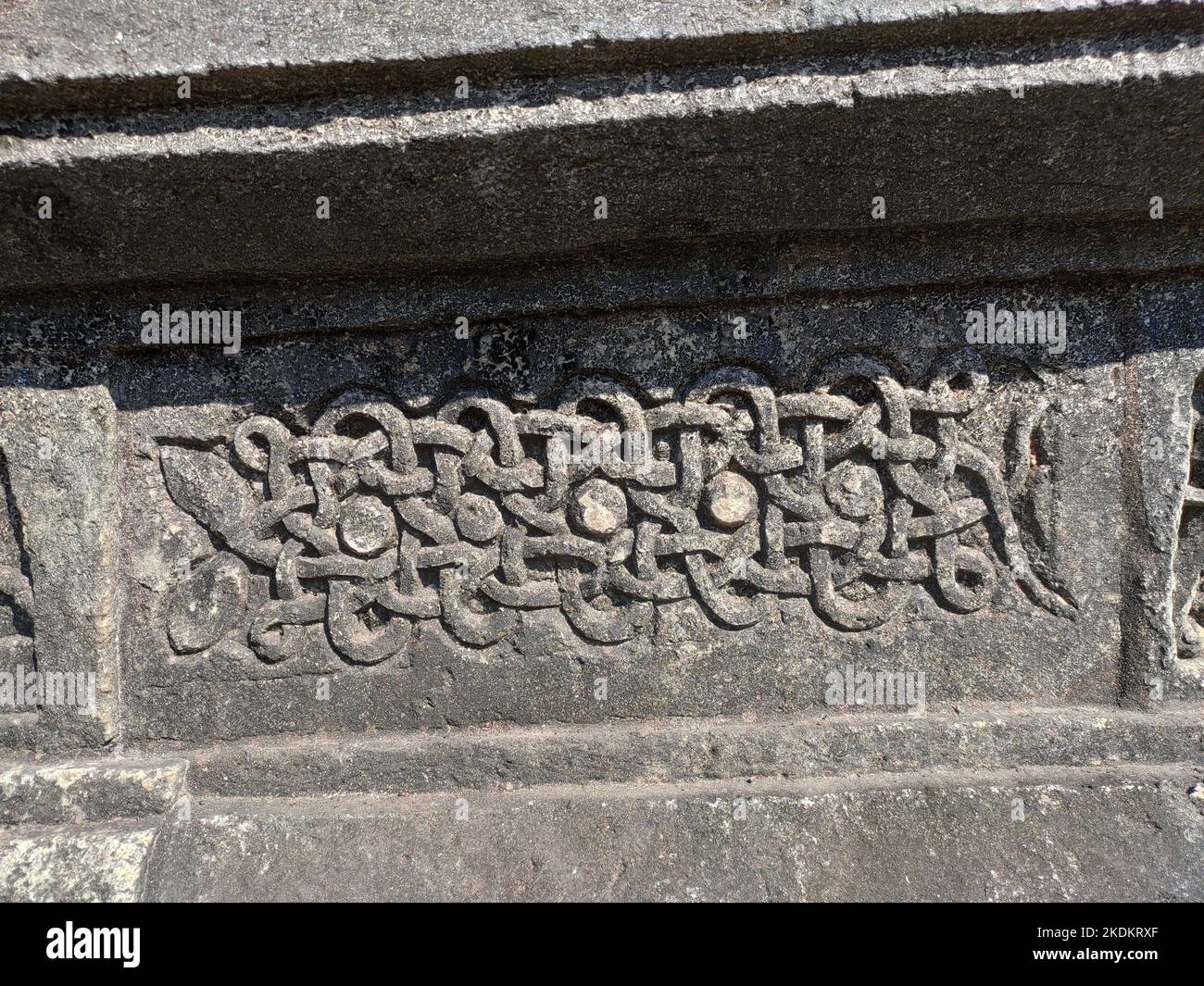 A close-up of a snake carving on Halebidu Temple’s wall, showcasing ...