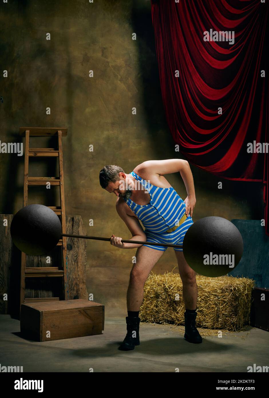 Vintage portrait of retro circus strongman wearing blue striped sports ...