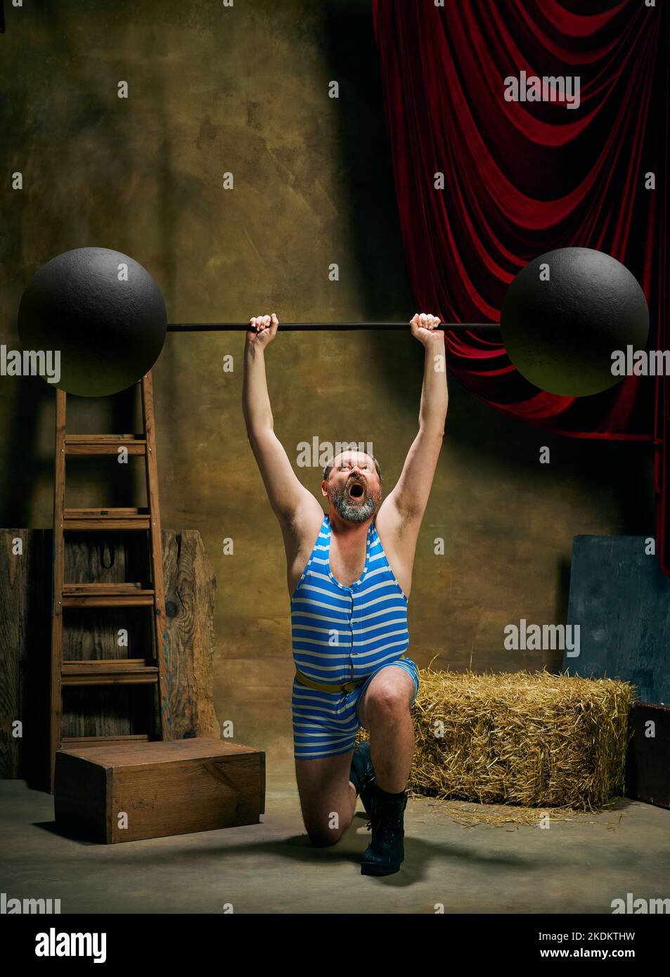 Vintage portrait of retro circus strongman wearing blue striped sports ...