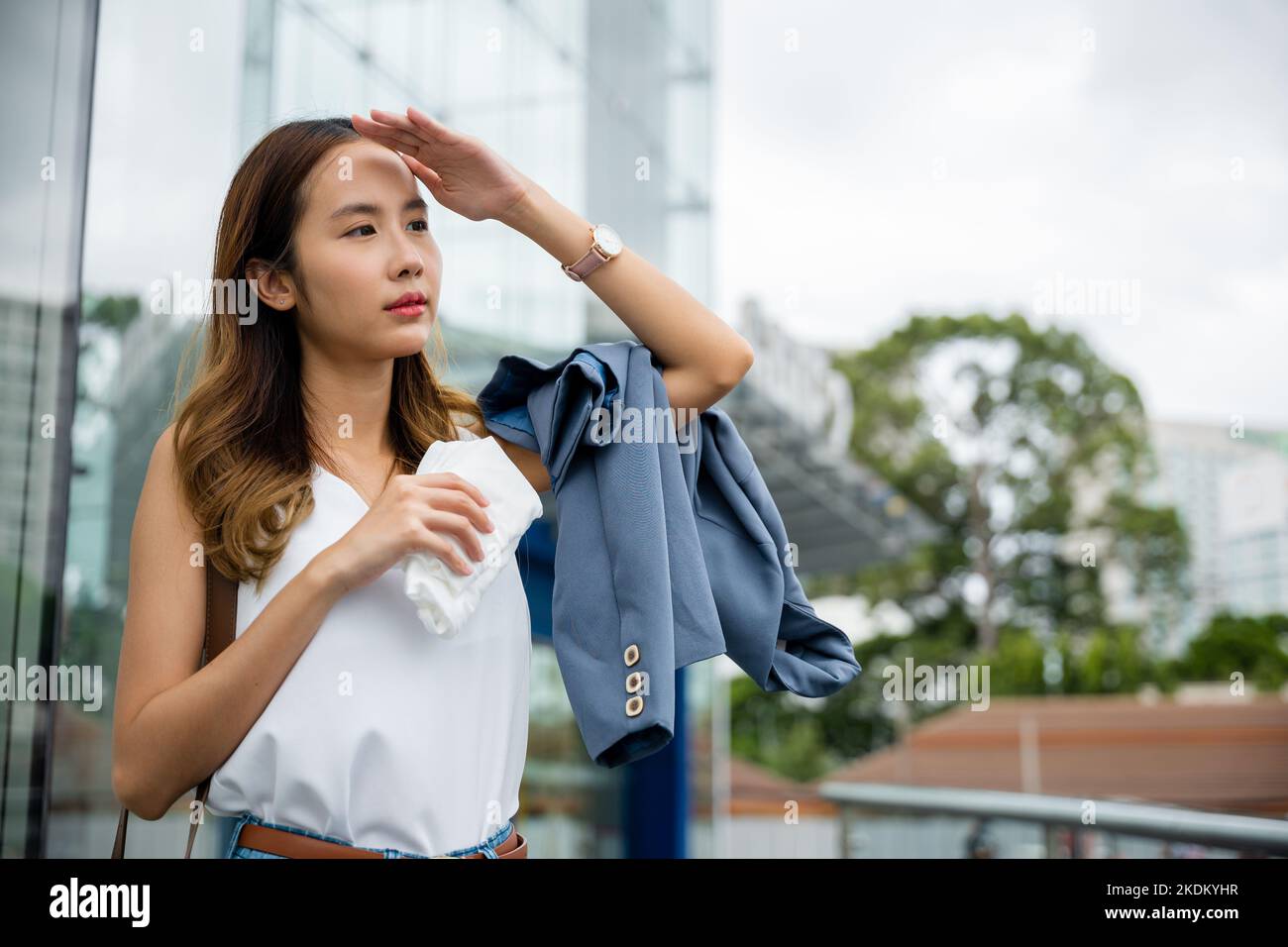 Asian beautiful business woman drying sweat her face with cloth in warm ...